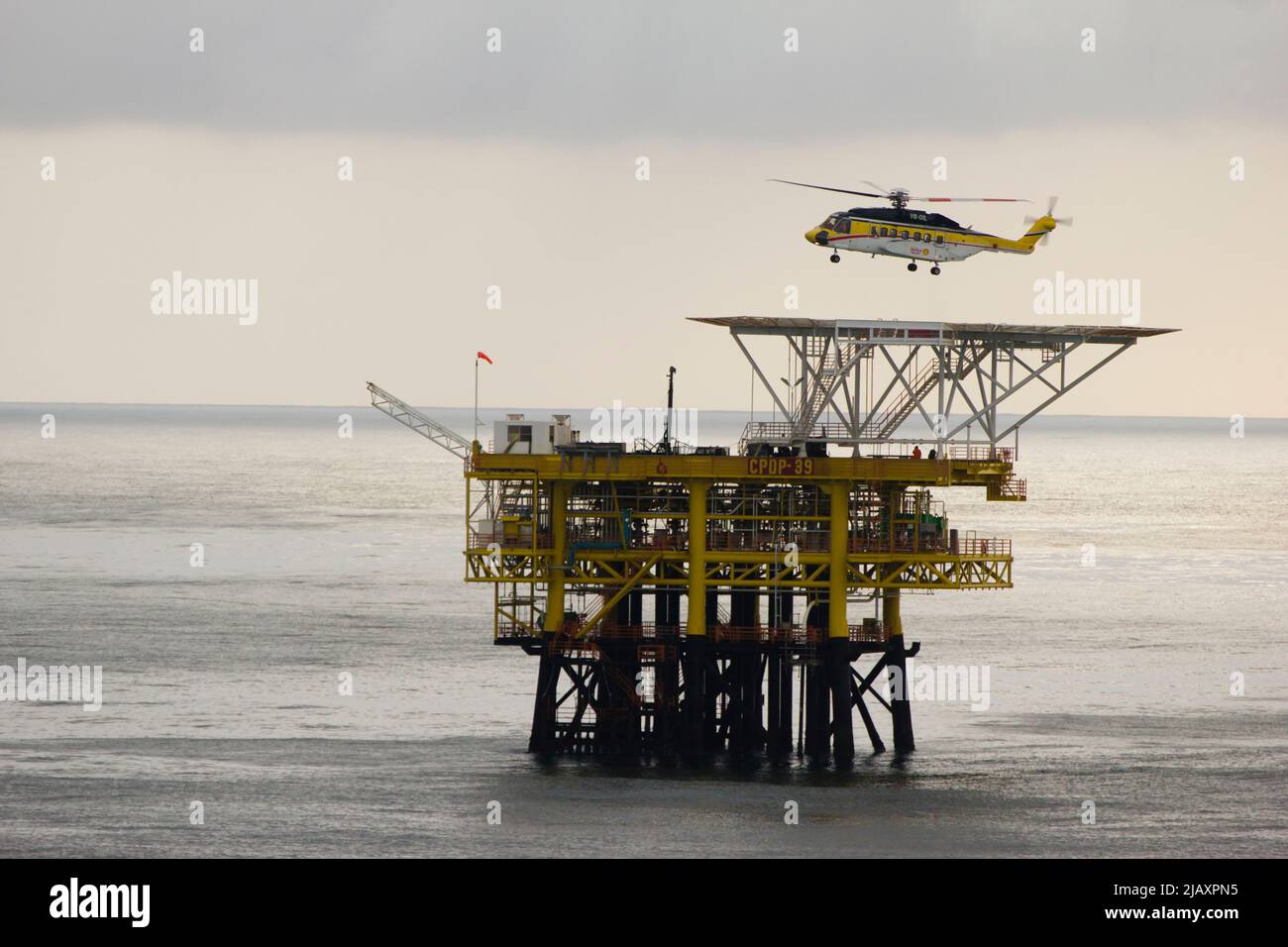 A helicopter on top of a offshore oil-platform transporting roughnecks ...