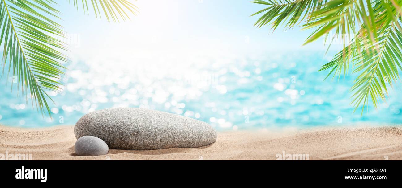 Tropical beach with palm leaves, bright sand and pebbles. Summer sea ...