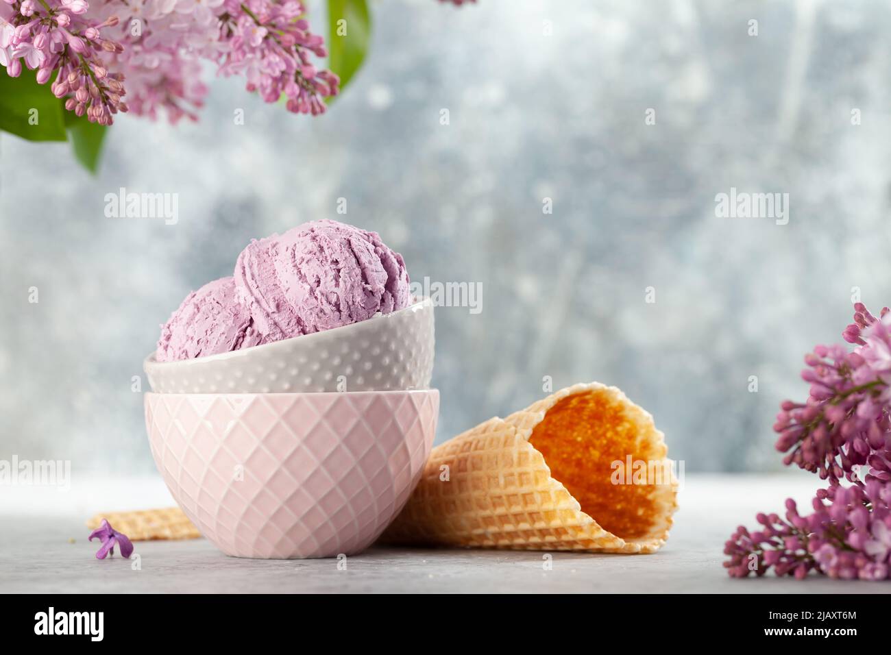Ice cream sundae in bowl, waffle cones and lilac flowers Stock Photo ...