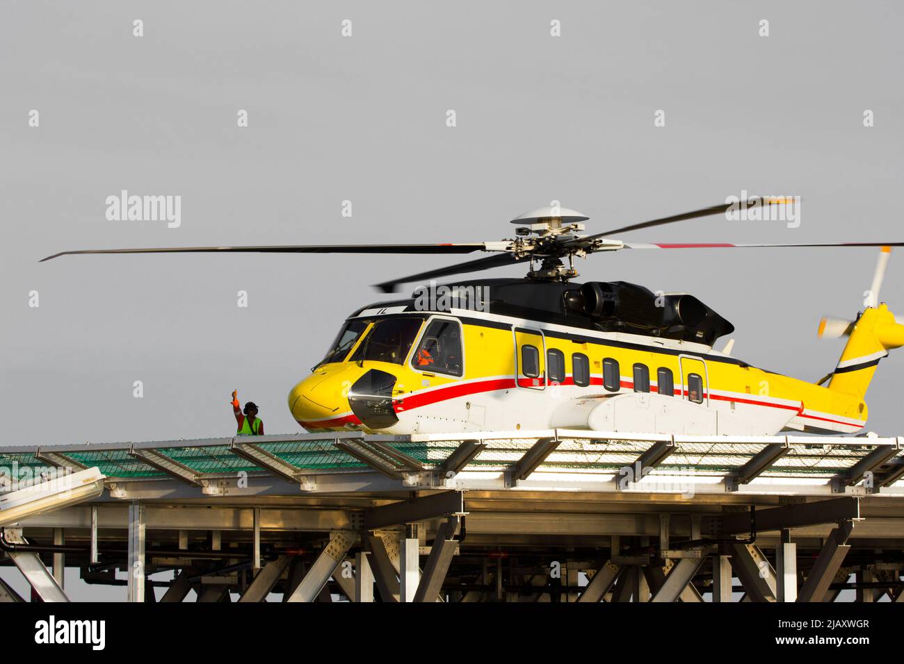 A helicopter on top of a offshore oil-platform transporting roughnecks ...