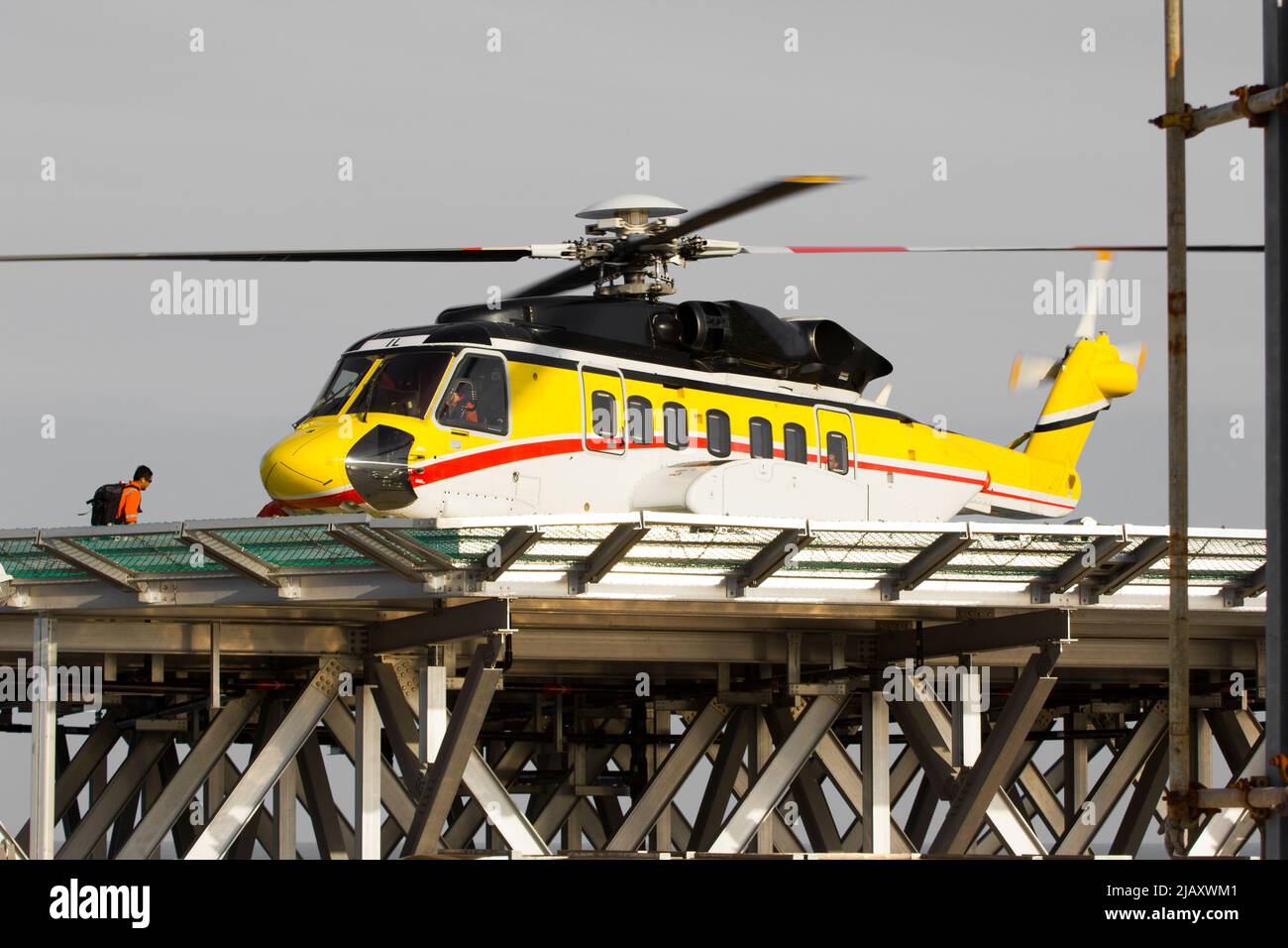 A helicopter on top of a offshore oil-platform transporting roughnecks ...