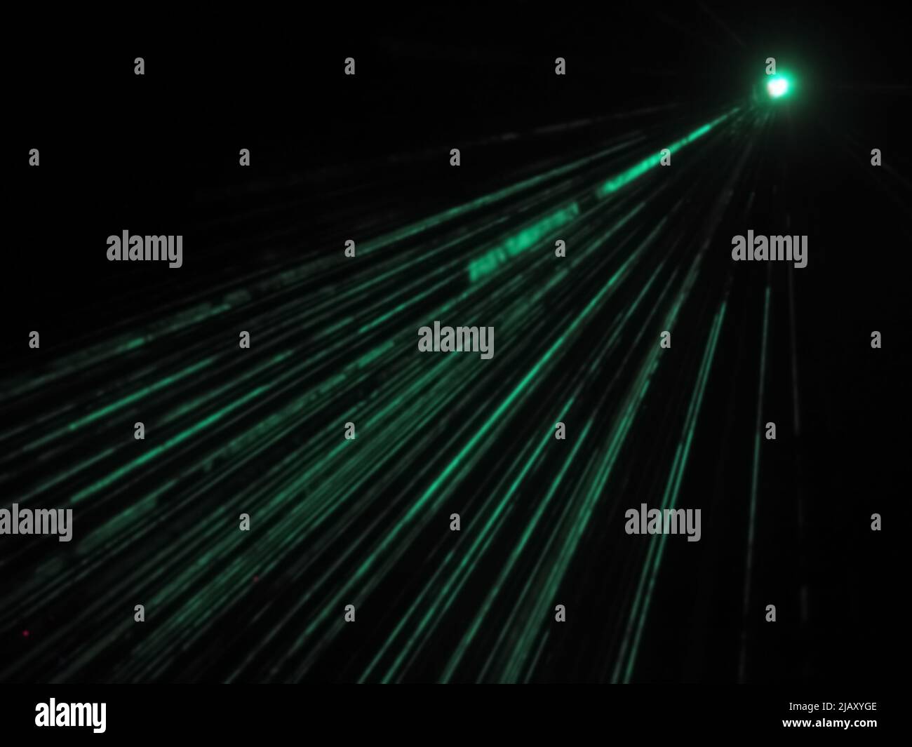 The outdoor projector shines bright emerald beams in dark. Laser show ...