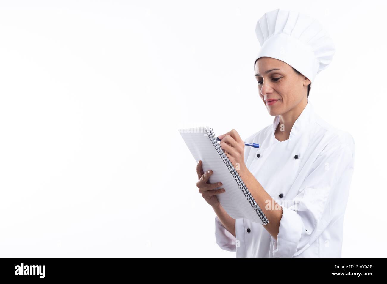 Woman chef writing in her notebook isolated on white background with ...