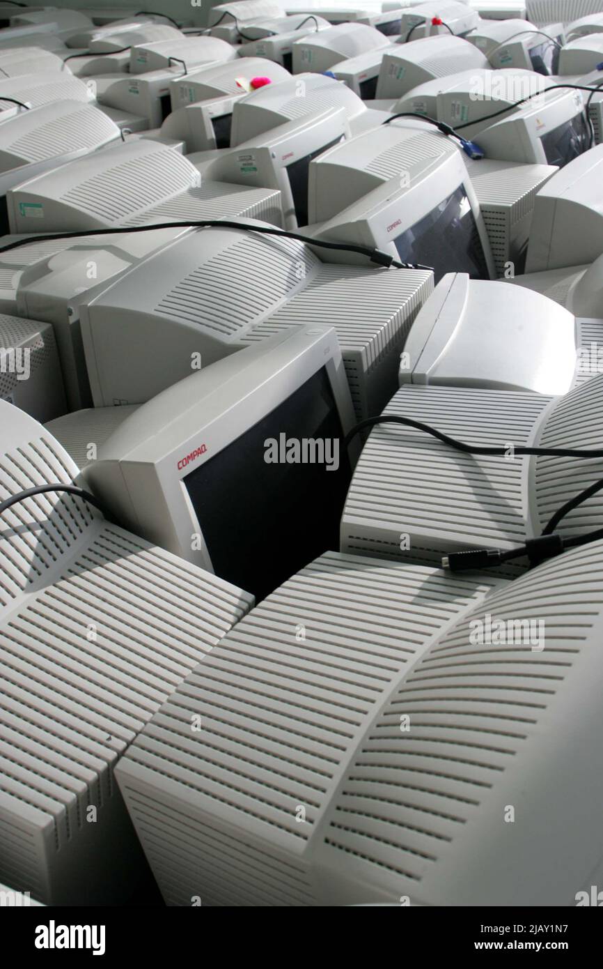 Old computer monitors stored in modern office area awaiting recycling ...