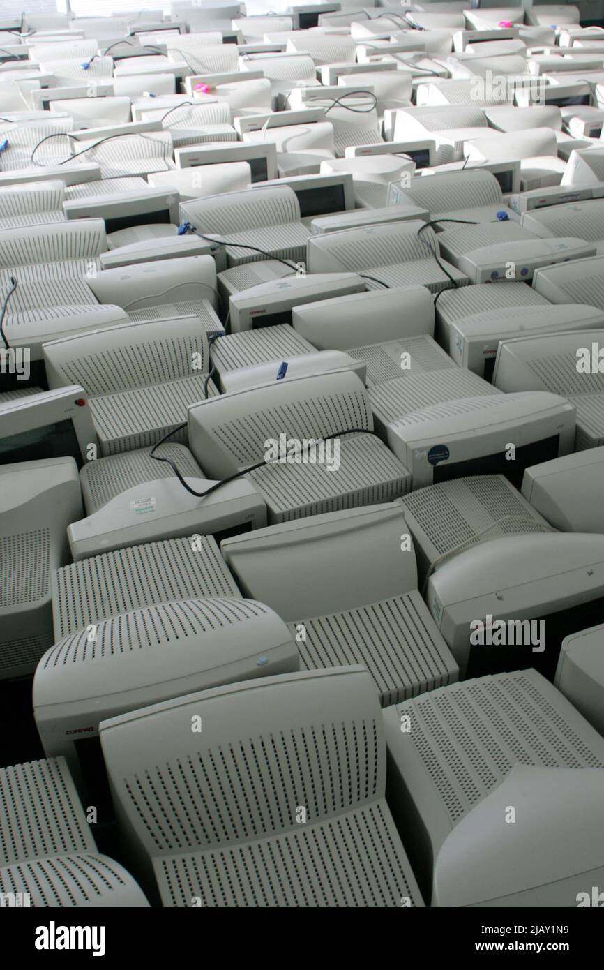 Old computer monitors stored in modern office area awaiting recycling ...