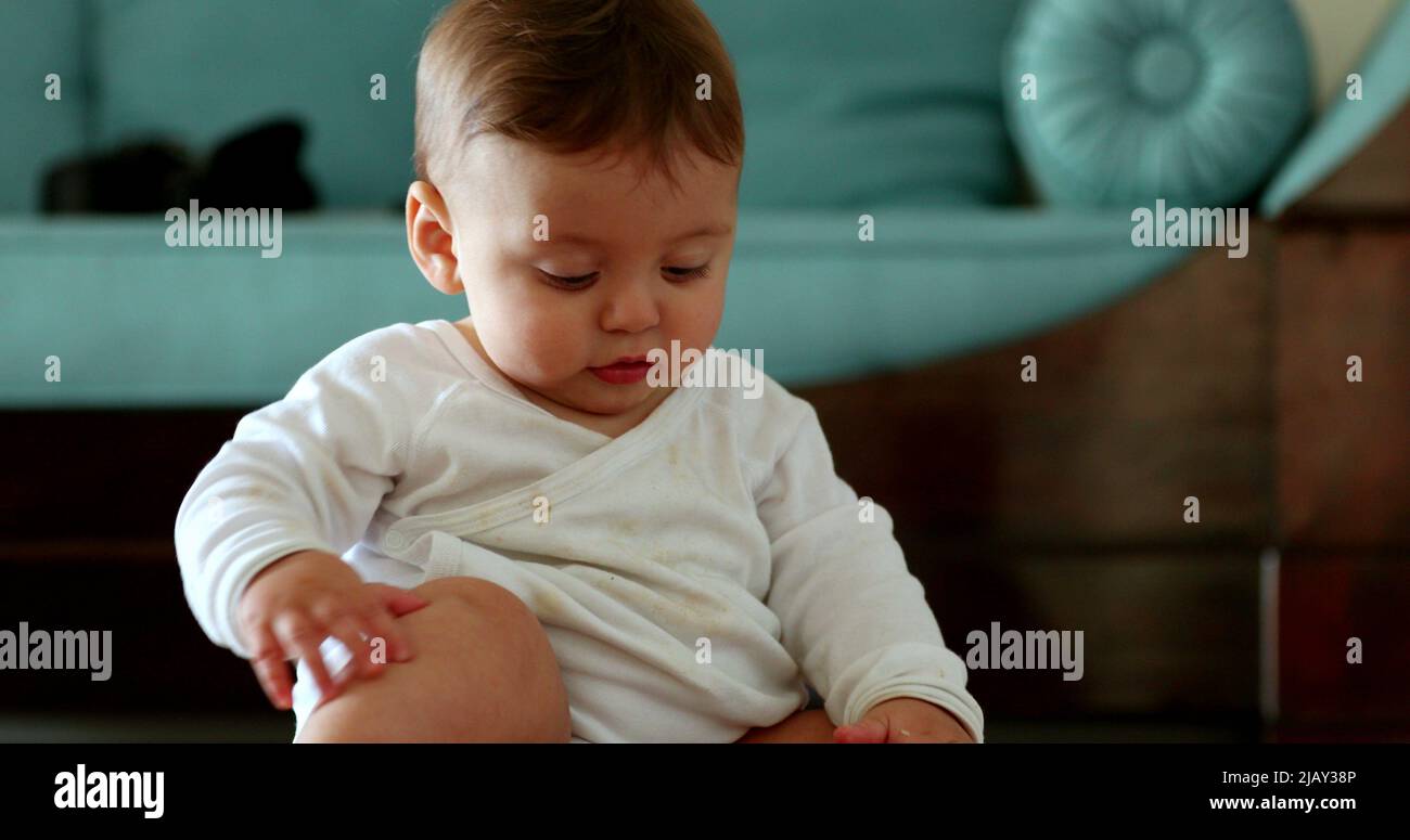 Cute baby toddler infant child on play mat wanting to bite his own feet ...