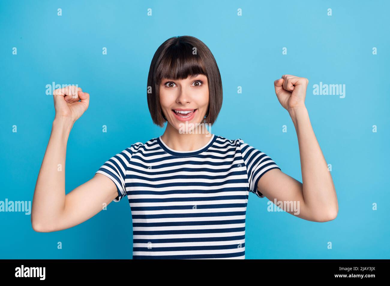 Photo of charming happy positive woman raise hands fists winner smile ...