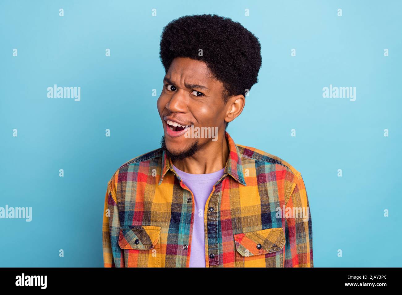 Photo of impressed young brunet guy wear yellow shirt isolated on blue ...