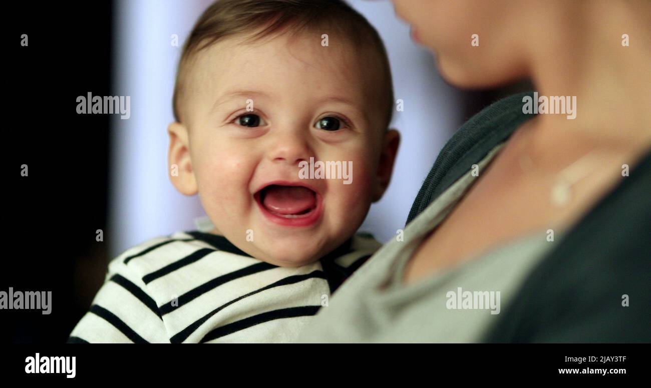 Happy smiling baby in mother arms. Parent holding adorable cute child ...