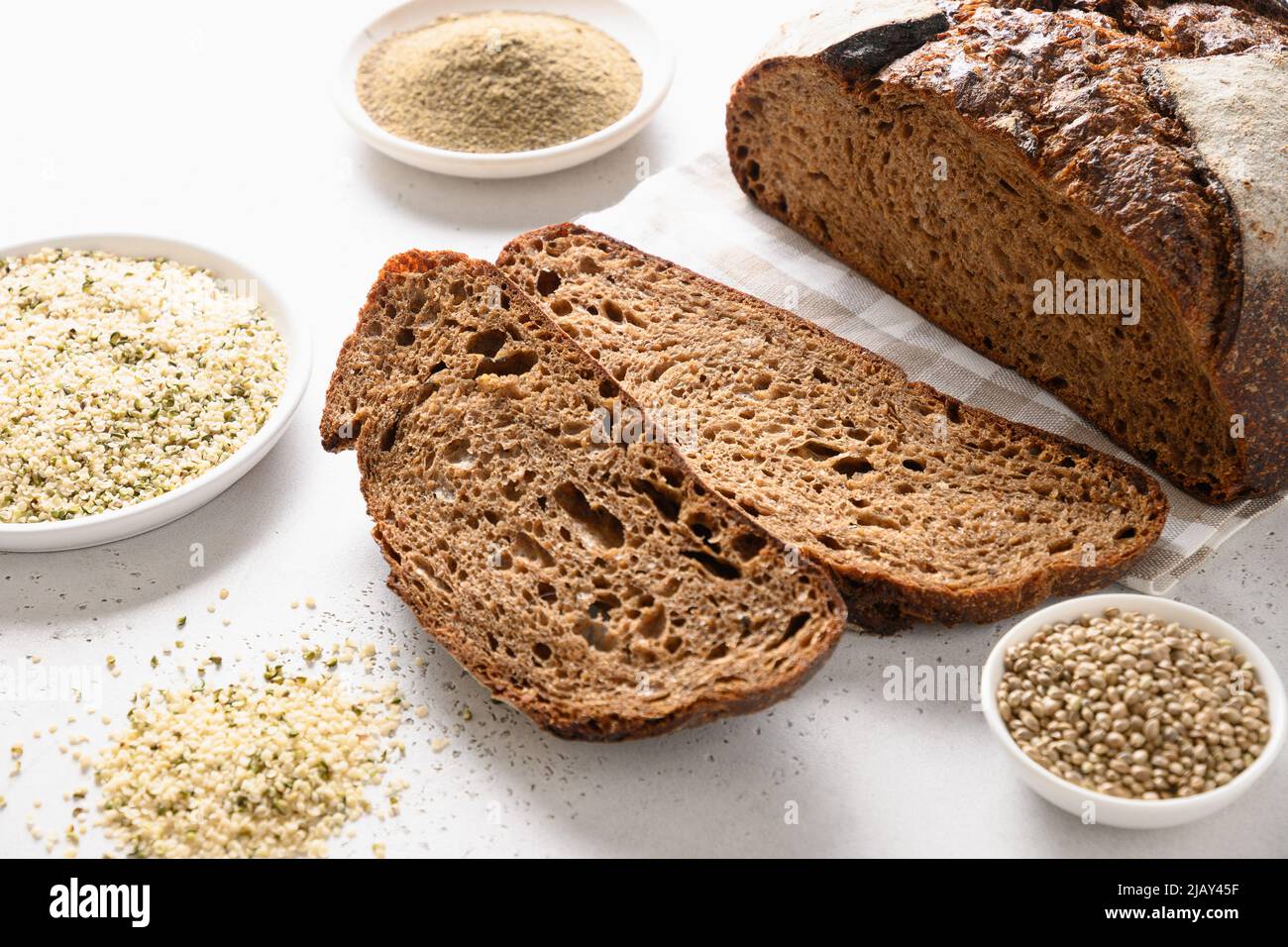 Loaf of Hemp bread, hempseeds and flour on white background. Close up ...
