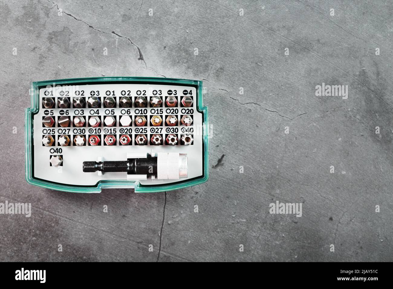 A set of metal power bits in a box on a gray background, for repair and ...
