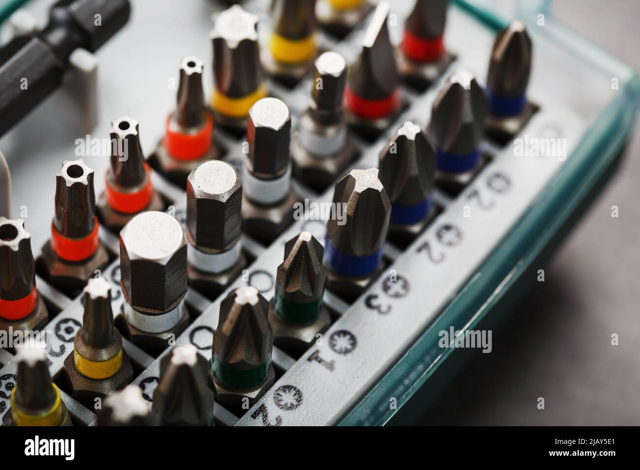 A set of metal power bits in a box on a gray background, for repair and ...