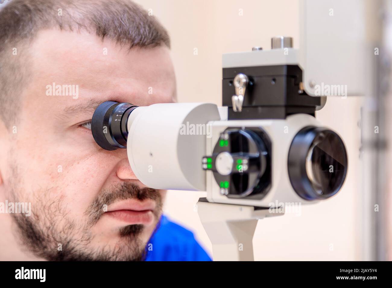 A male ophthalmologist checks a patient's vision with a modern device ...