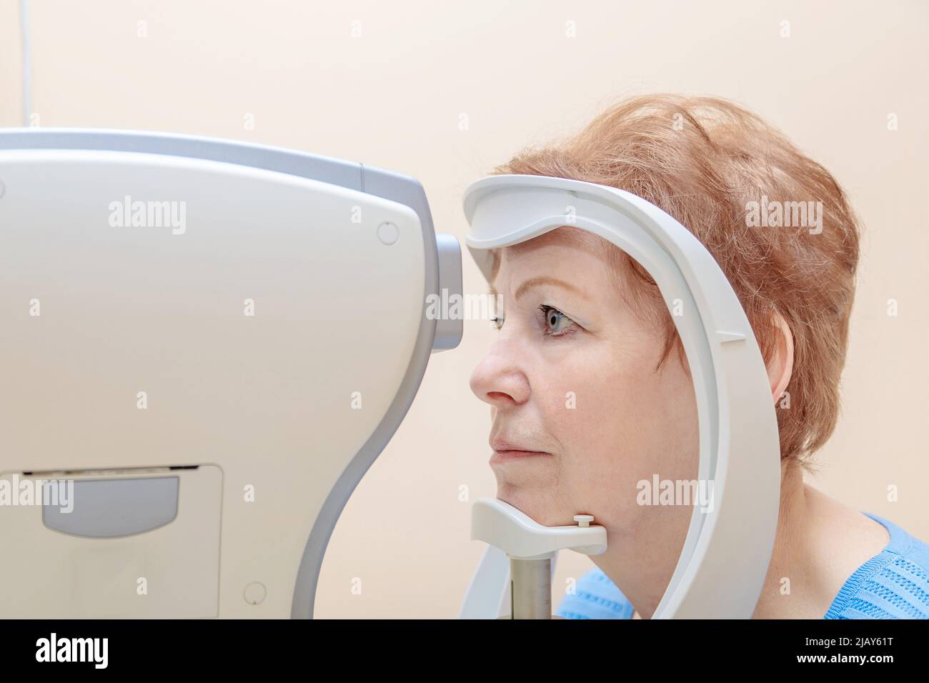 An adult woman at an ophthalmologist's appointment checks her vision on ...