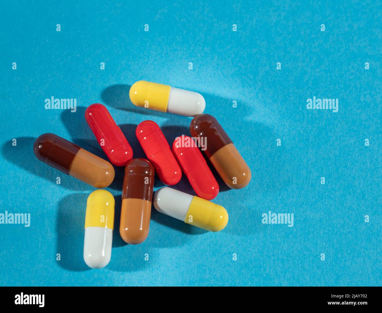 Multicolored medical capsules on a blue background. High quality photo ...