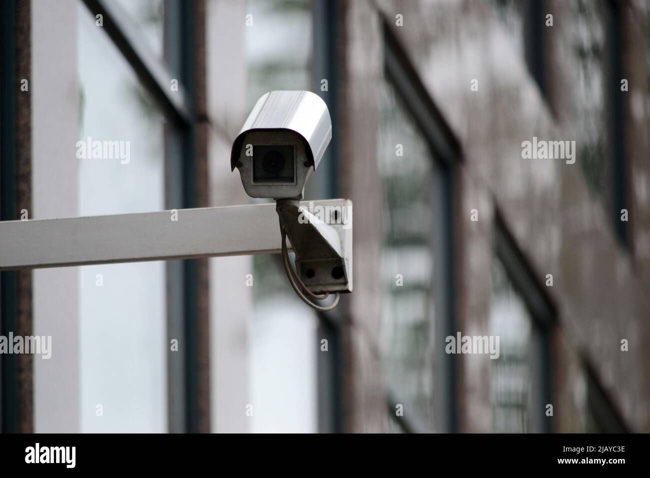 CCTV - security camera, office building in background Stock Photo - Alamy
