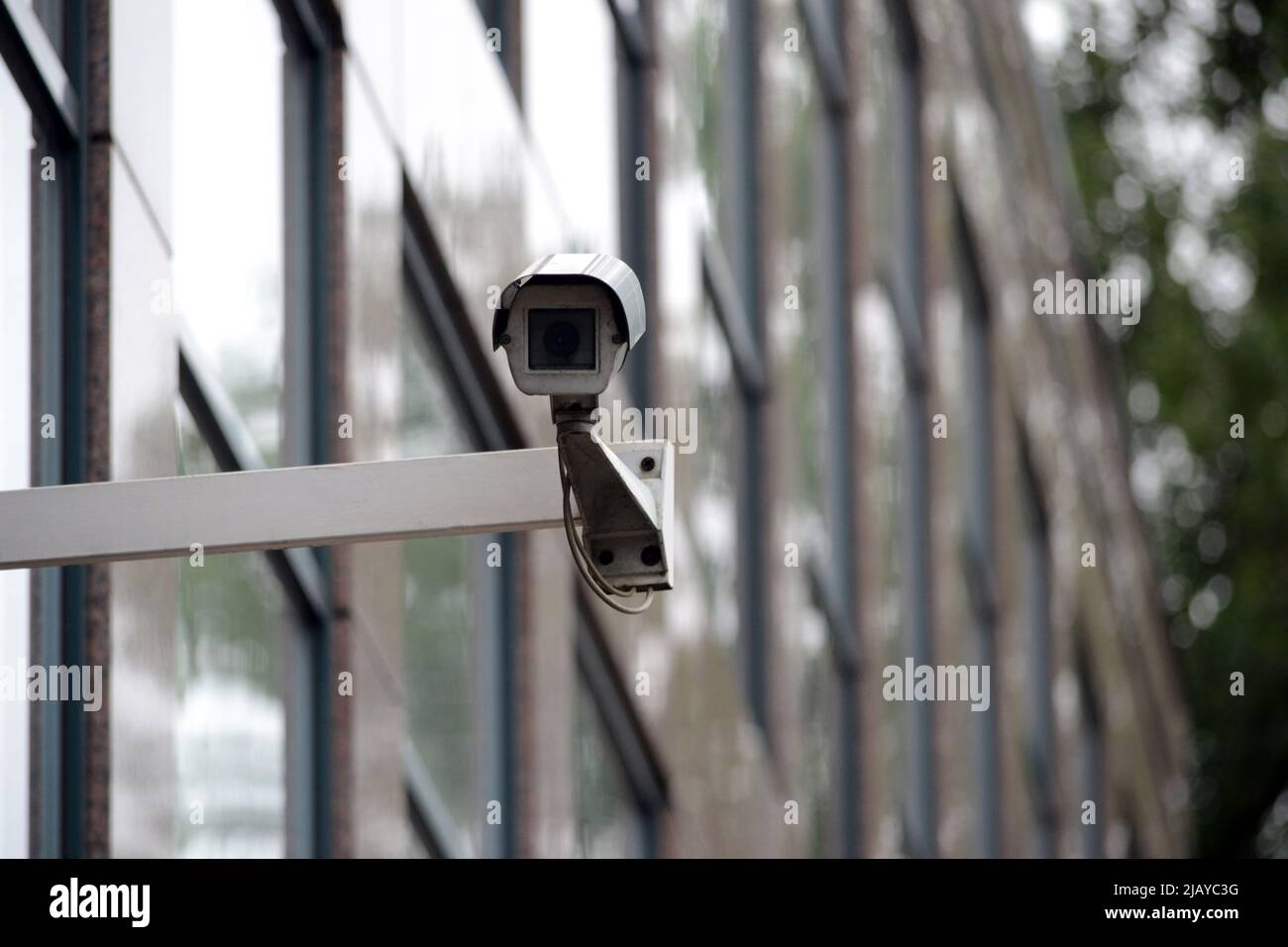 CCTV - security camera, office building in background Stock Photo - Alamy