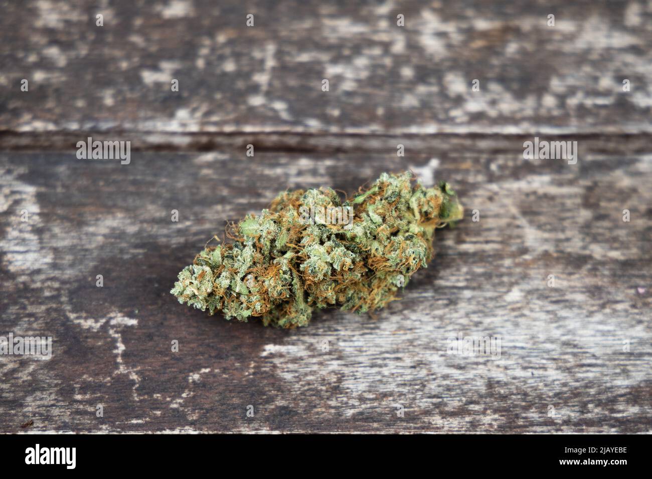 Dried cannabis bud on the wooden table, medical marijuana leaves Stock ...