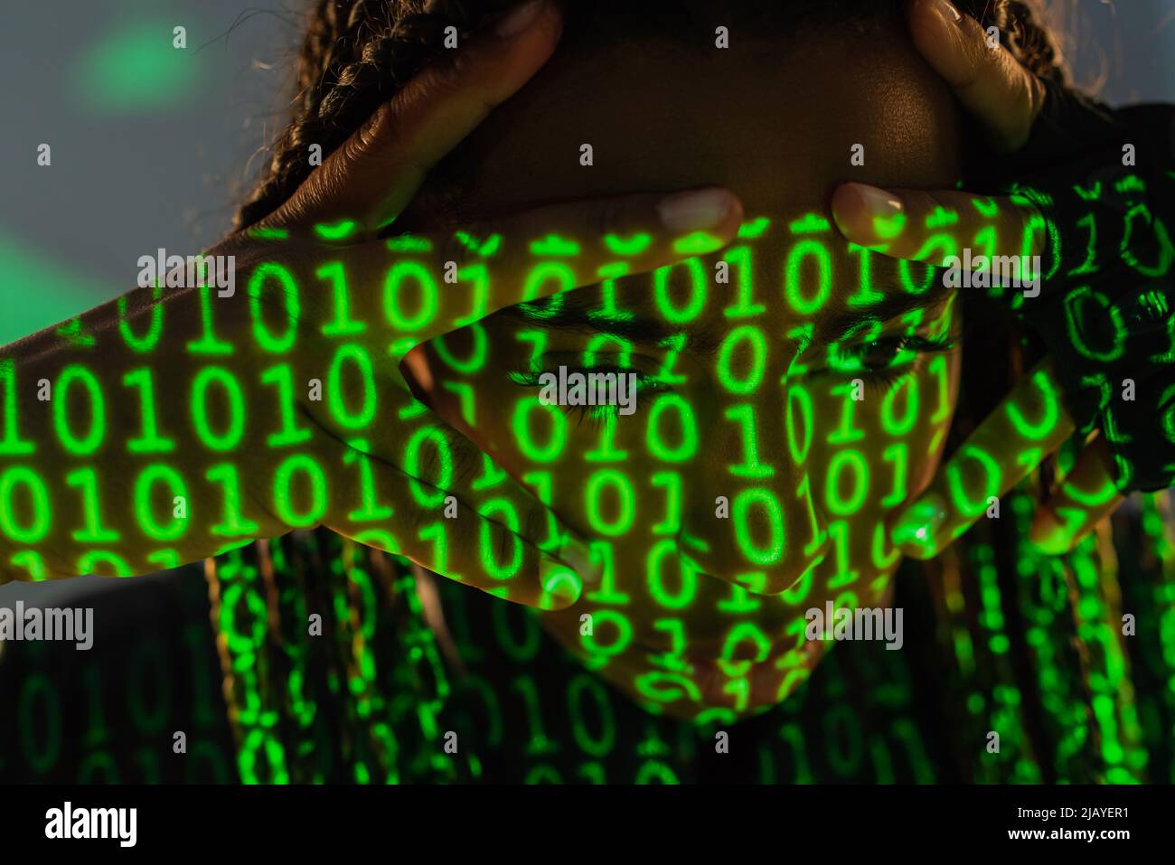 African american woman with projection of green binary code on grey ...