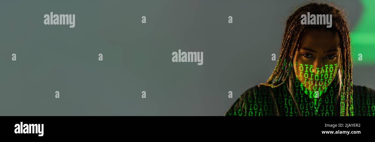 African american woman with binary code on face looking at camera on ...