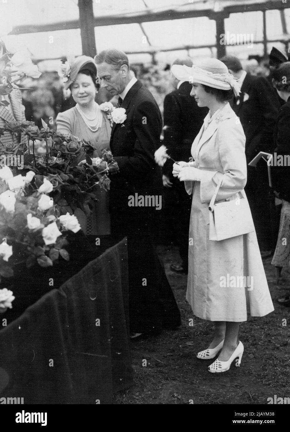 The King and Queen, both wearing carnation button-holes, admire roses ...