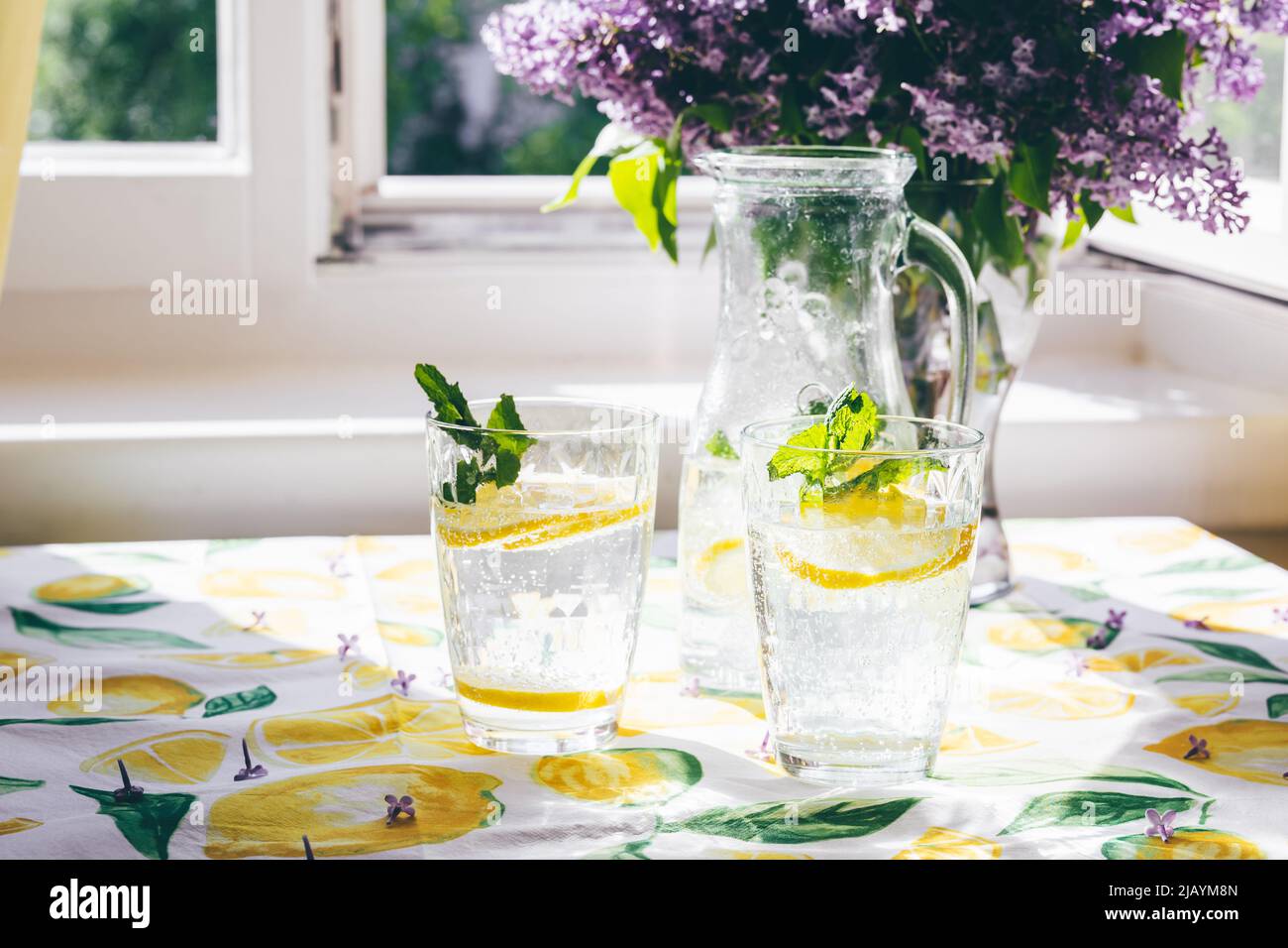 Water with sliced lemon on kitchen background. Summer refreshment ...
