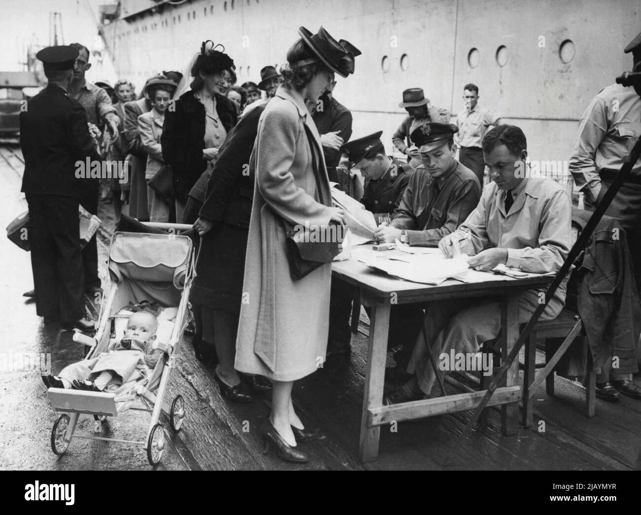 War Brides Leave For U.S. - American army men check on wharf as they ...
