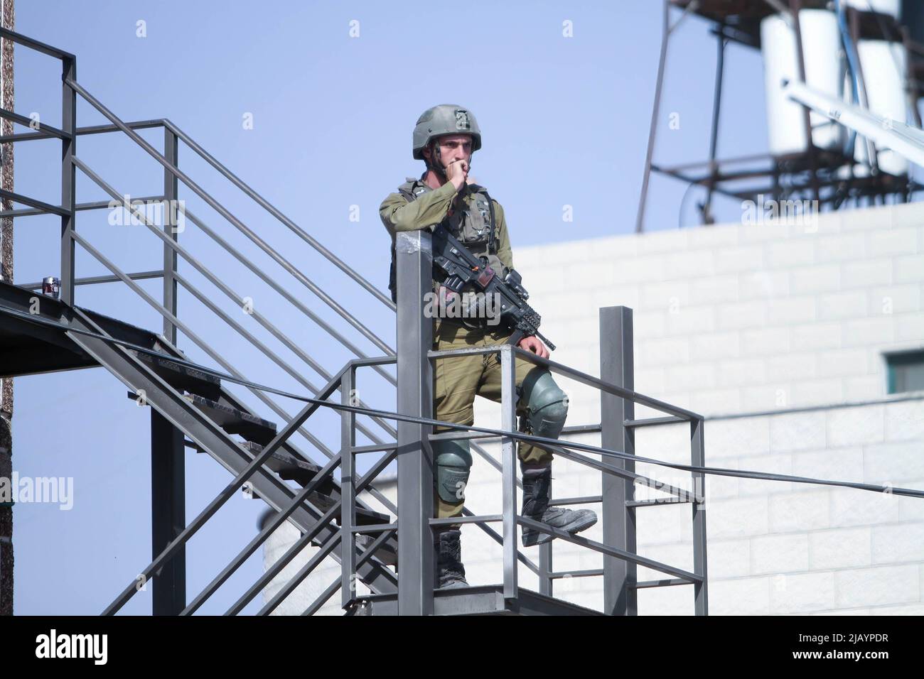An Israeli soldier guards the street to prevent friction between ...