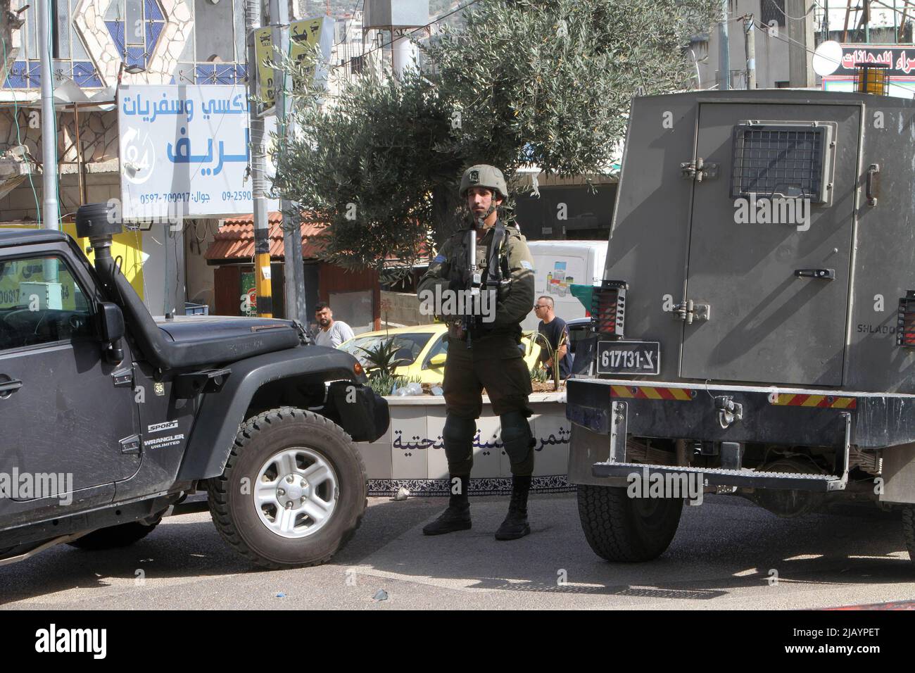 Israeli soldier guards the street to prevent friction between ...