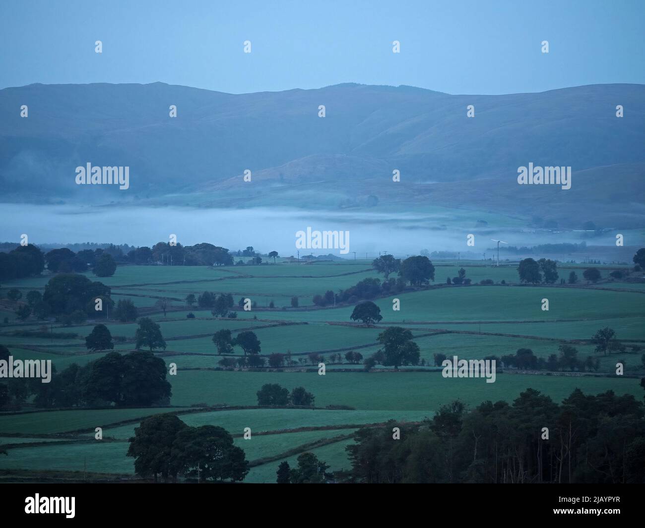 Moody atmospheric landscape image with misty early morning cloud ...