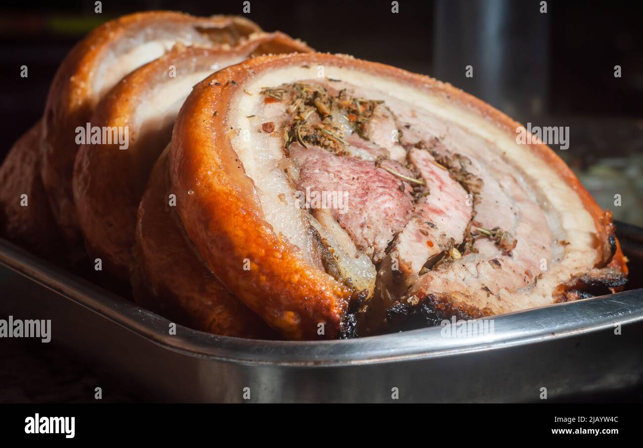 traditional roast of Italian Porchetta, sliced and placed on a metal ...
