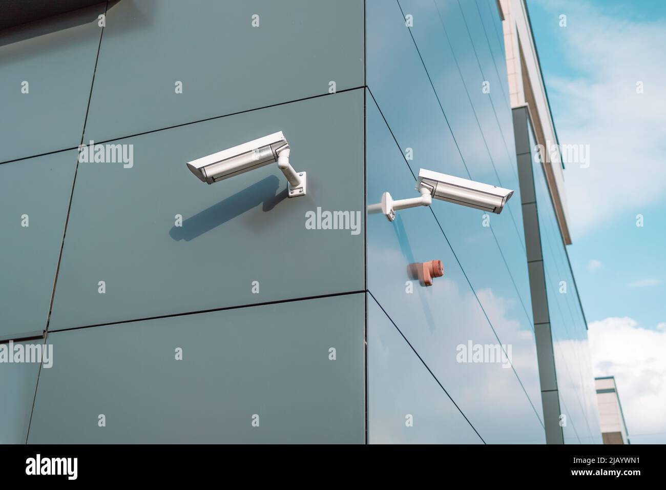 White surveillance camera built into the metal wall of the office ...