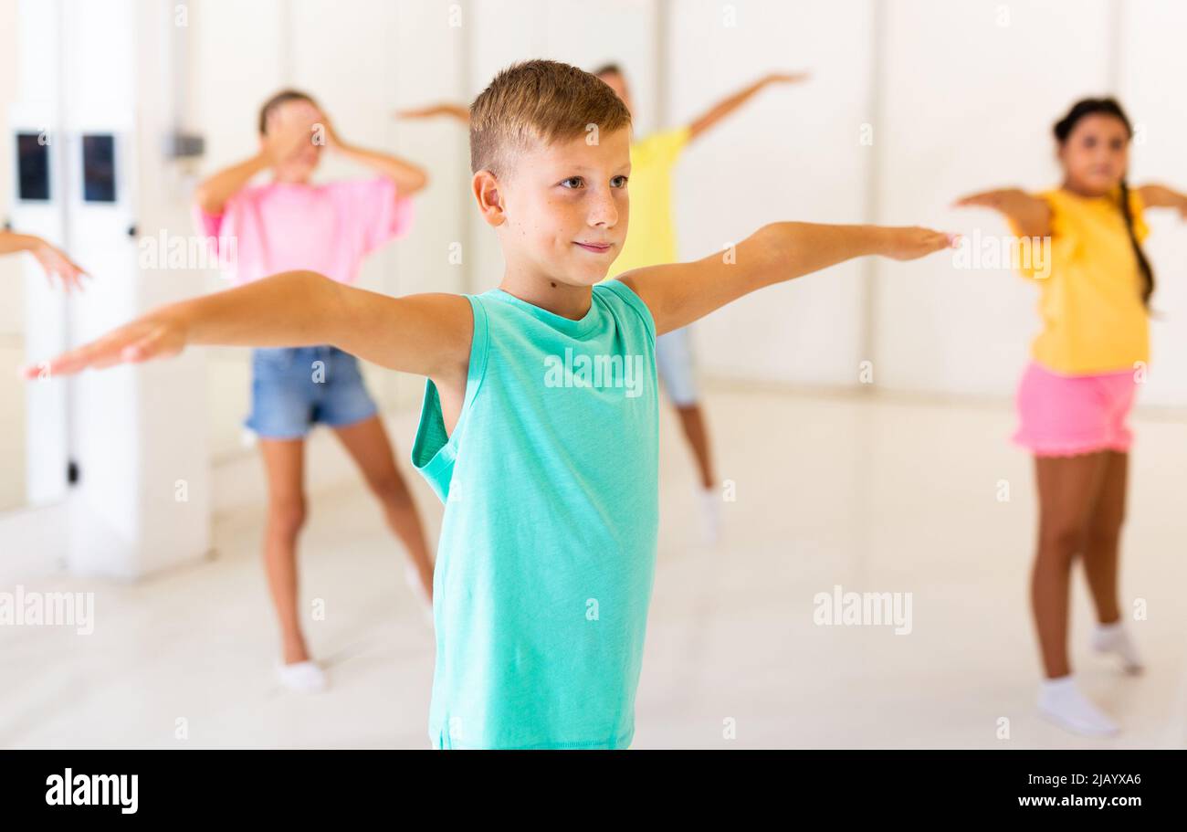 Preteen boy doing stretching workout before training in choreography ...