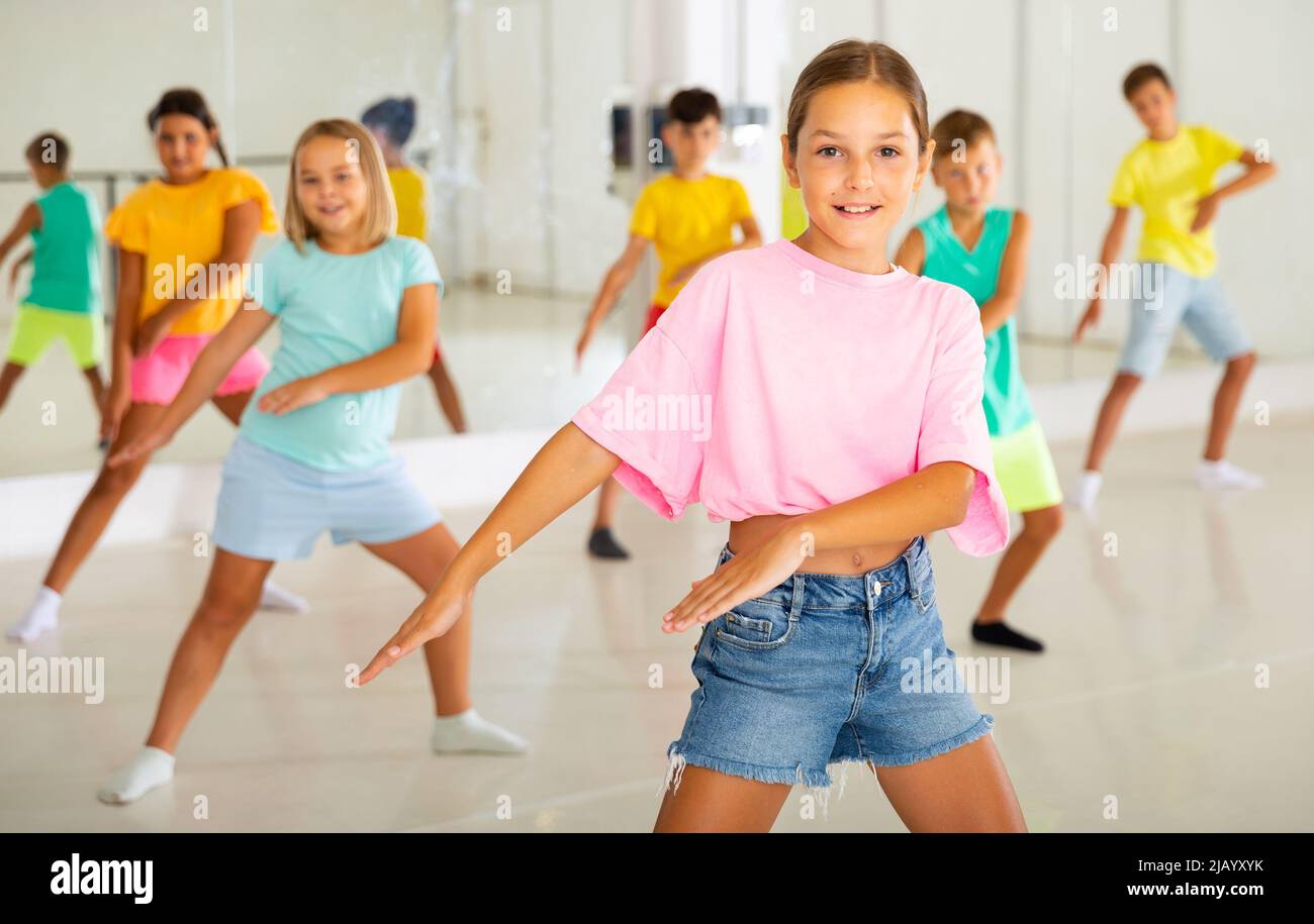 Happy tween girl dancing during group class in choreographic studio ...