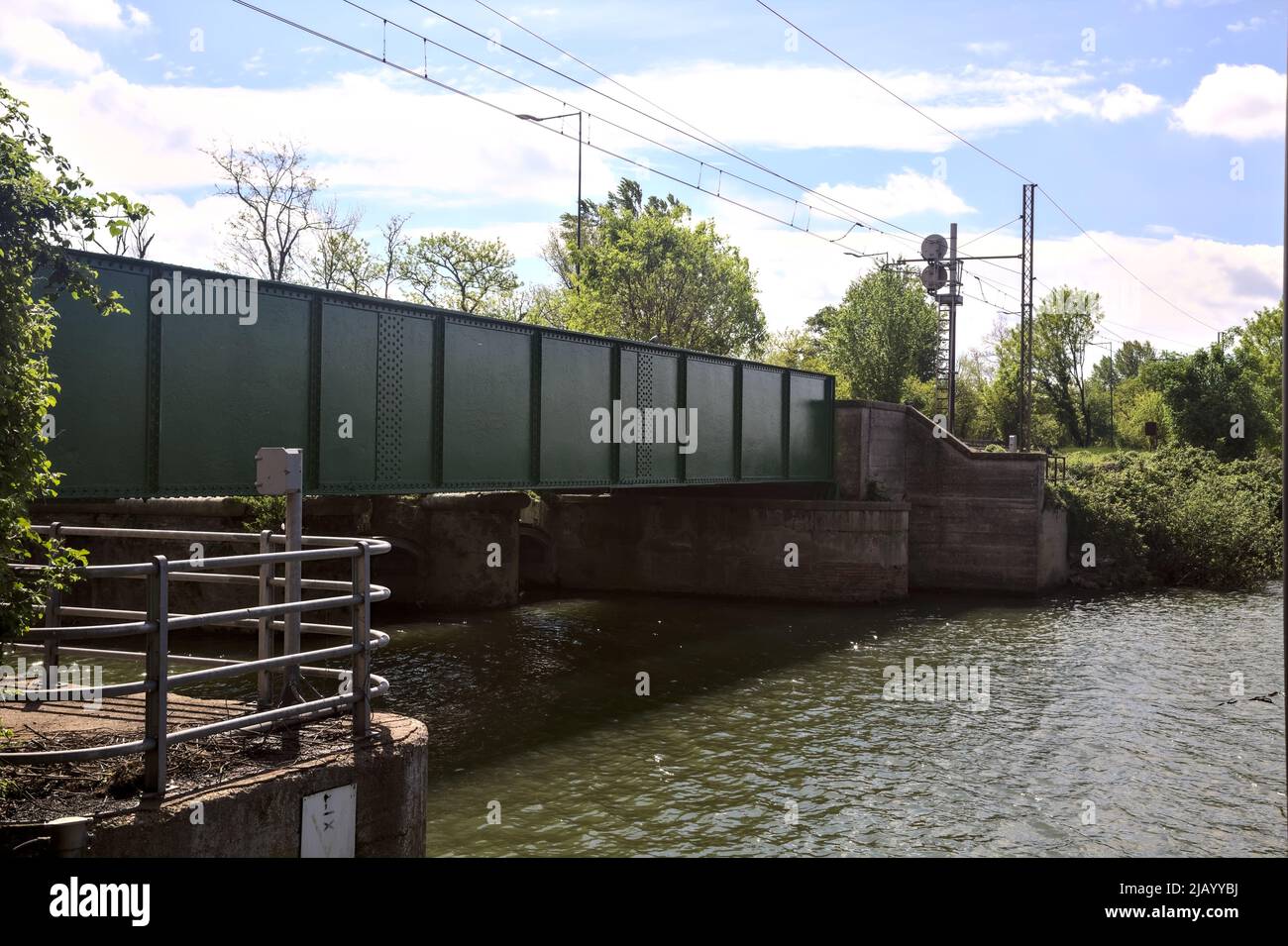 Short railroad bridge on a lake in a park Stock Photo - Alamy