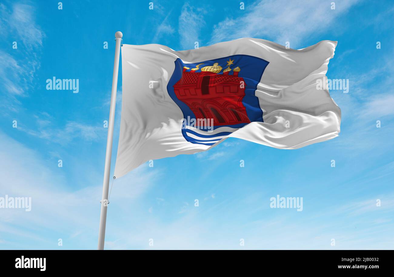 official flag of Aalborg , Denmark at cloudy sky background on sunset ...