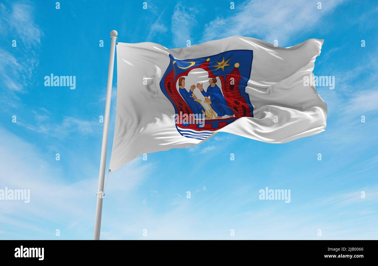 official flag of Aarhus , Denmark at cloudy sky background on sunset, panoramic view. Danish ...