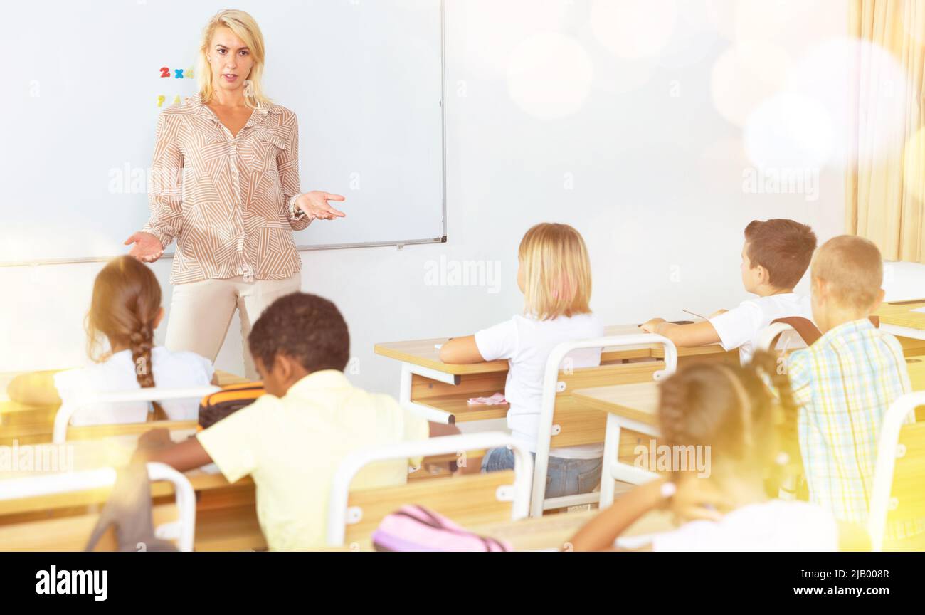 Woman teacher lecturing to pupils at classroom Stock Photo - Alamy