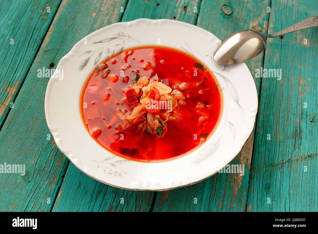 Russian vegetarian borsch with cabbage in white plate on turquoise ...