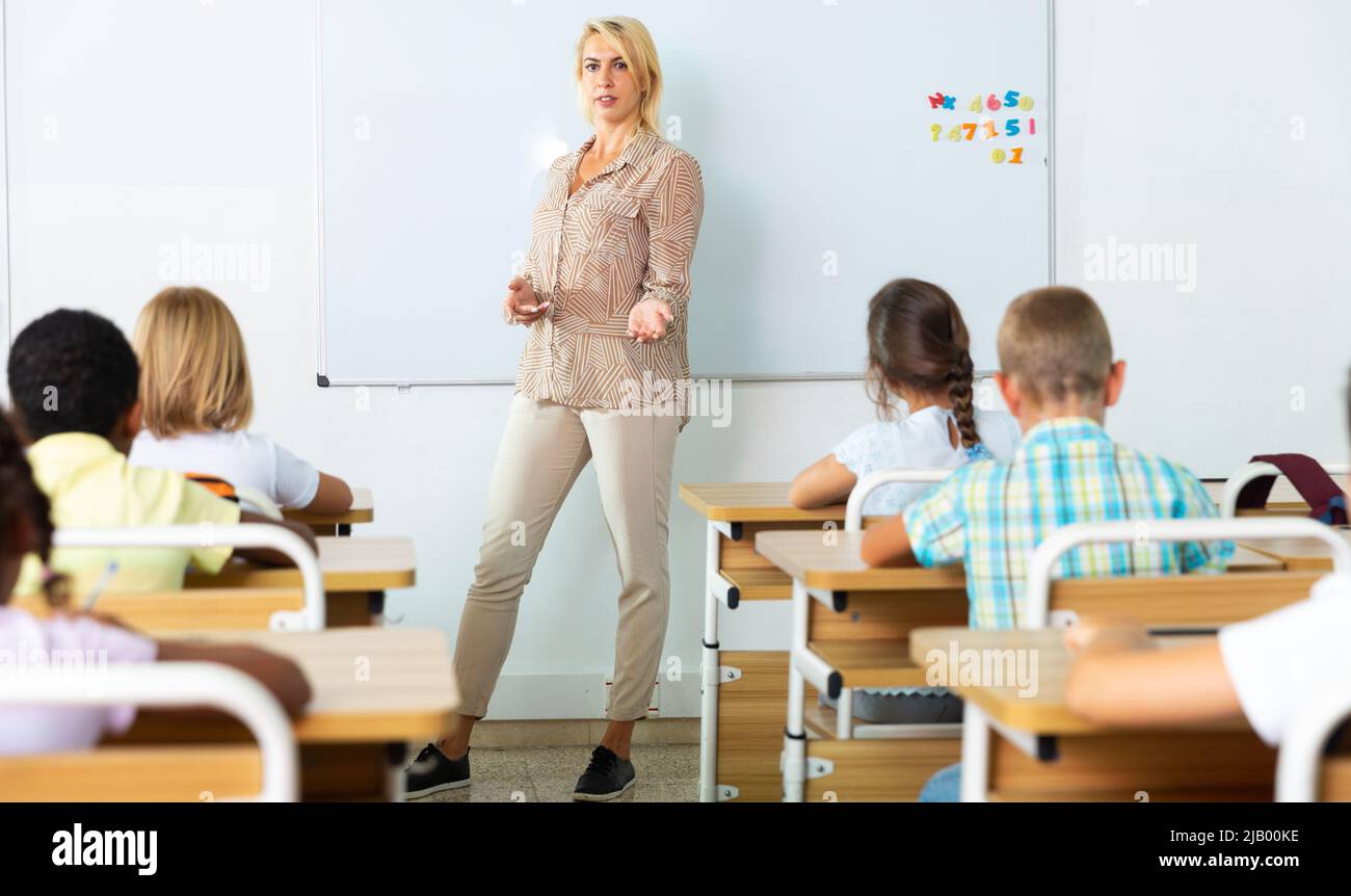 Woman teacher lecturing to pupils at classroom Stock Photo - Alamy