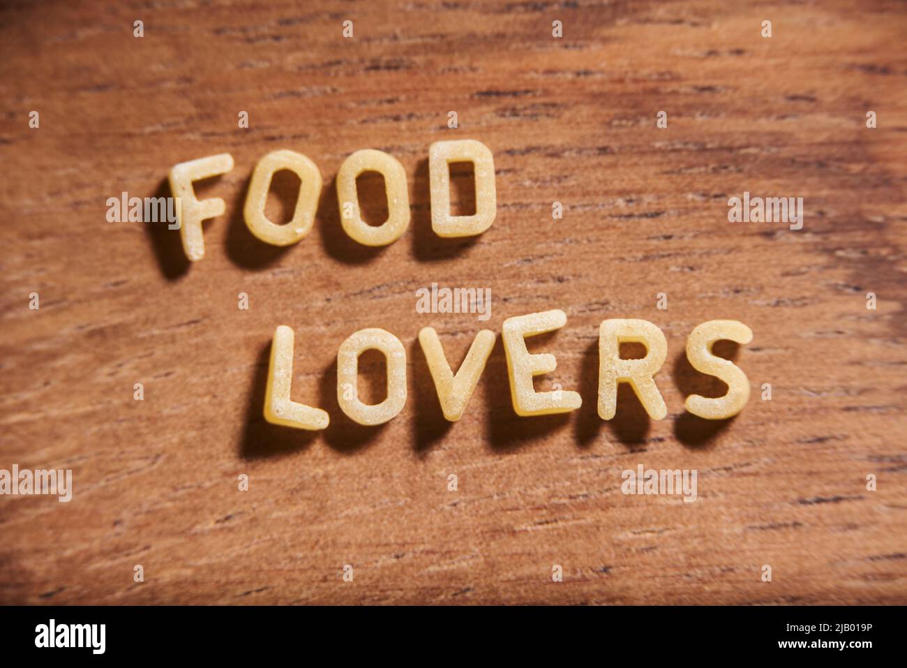 Text Food lovers formed with alphabet soup pasta letters on a wooden ...