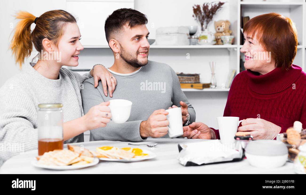 Happy family over cup of coffee at home Stock Photo - Alamy