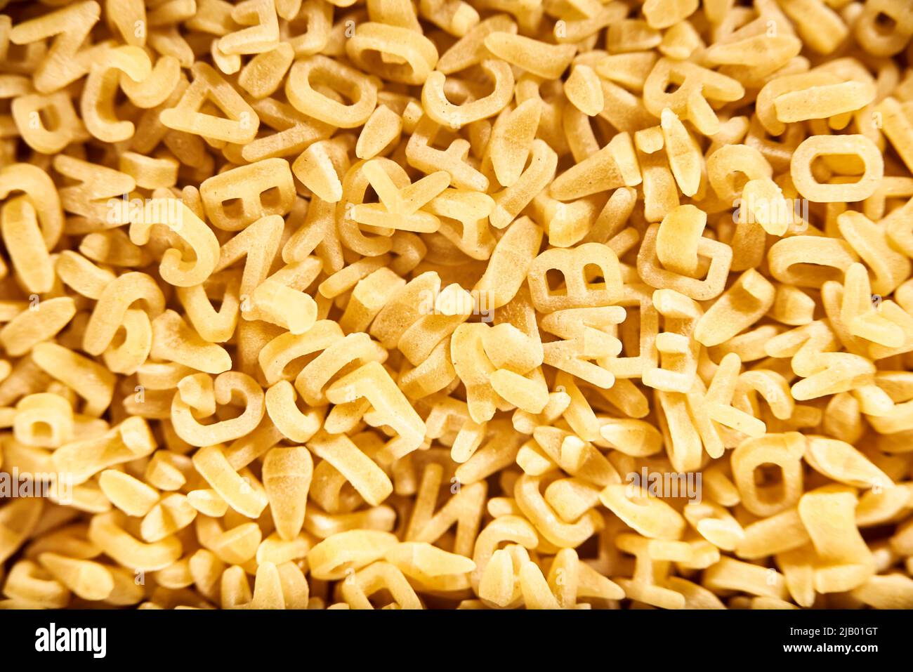 Uncooked alphabet soup pasta letters background. Concepts: healthy ...