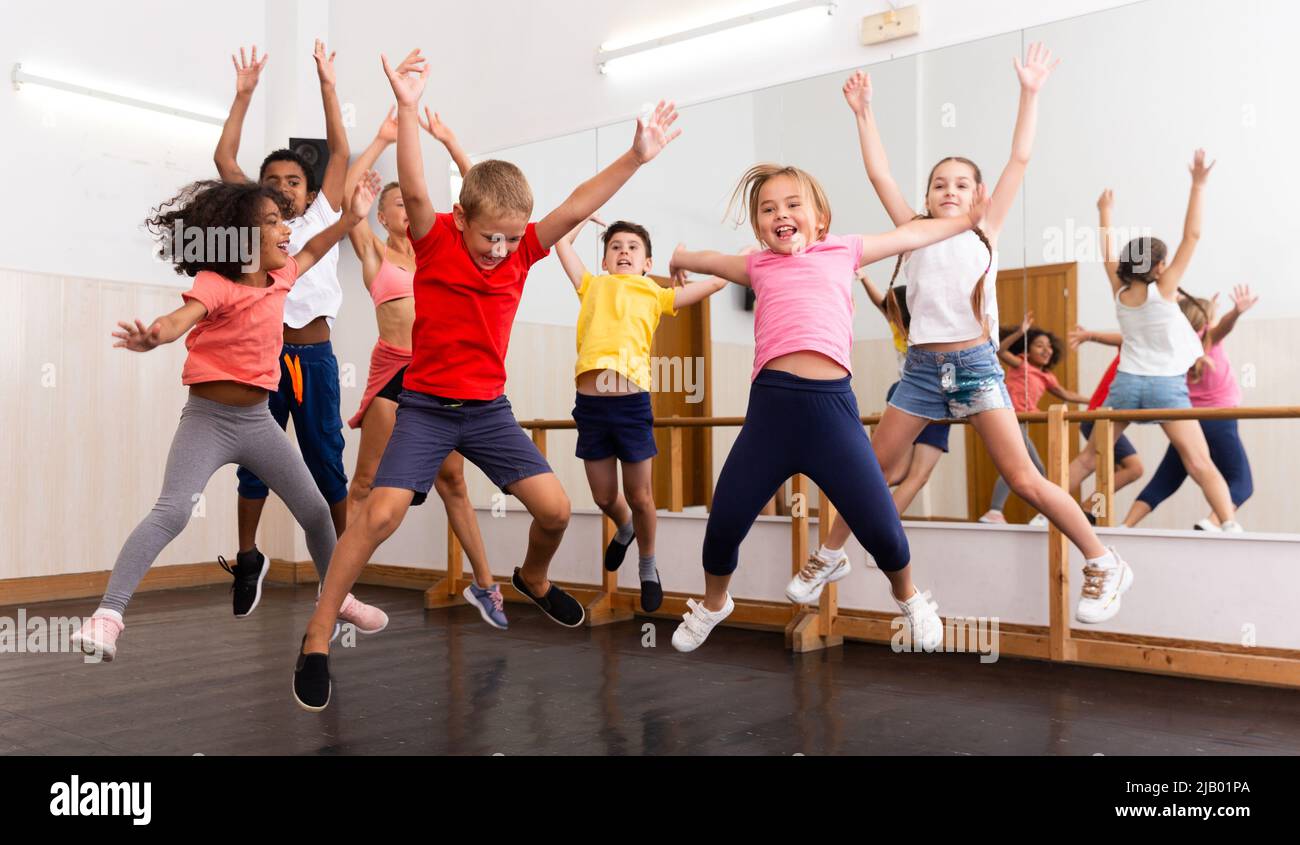 Cheerful preteen boys and girls jumping in dance class Stock Photo - Alamy