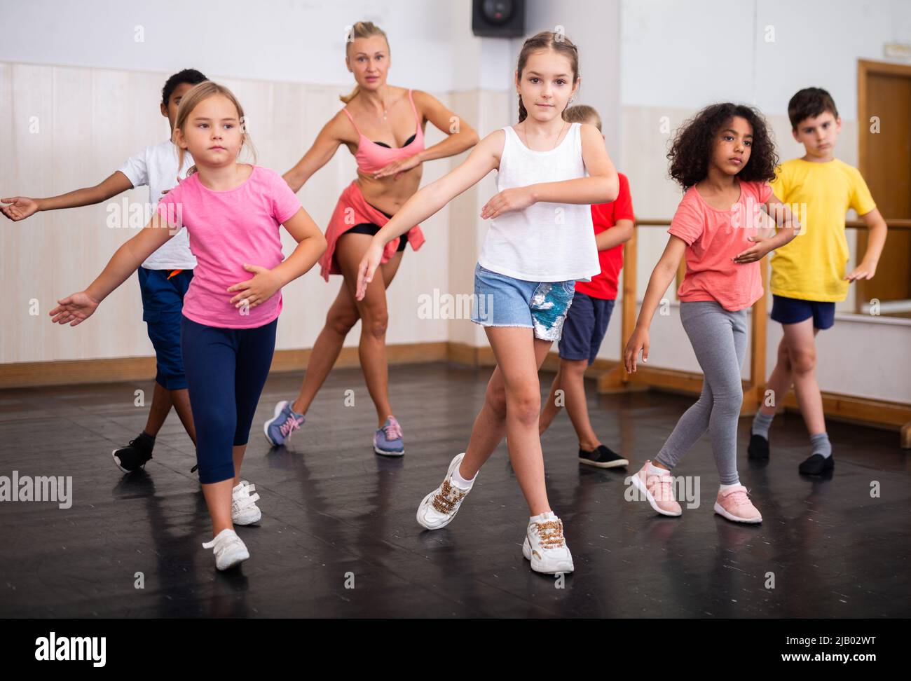 Tween girl training vigorous dance during group class Stock Photo - Alamy