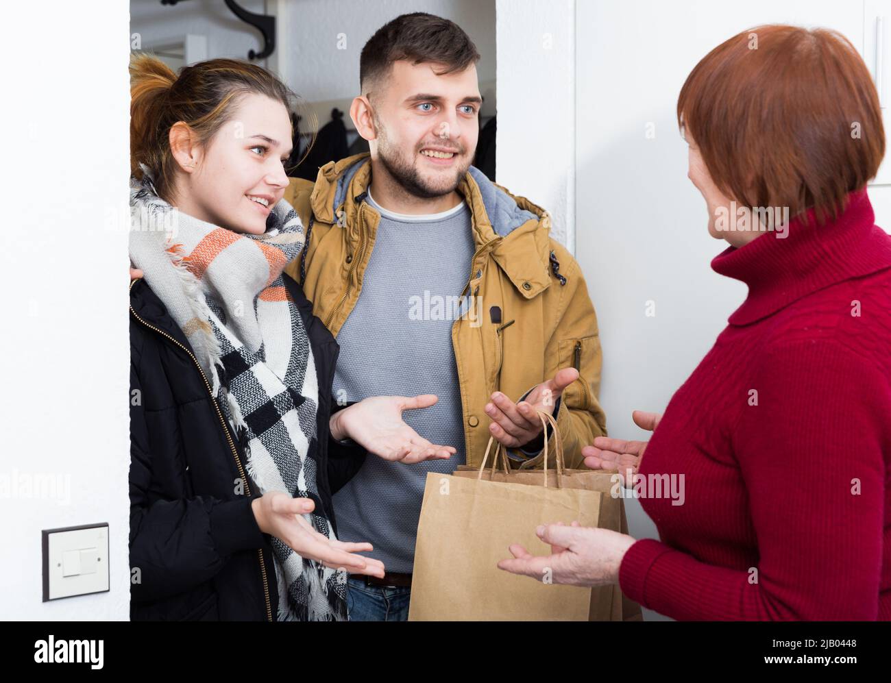Smiling guy with wife visiting his mother Stock Photo - Alamy