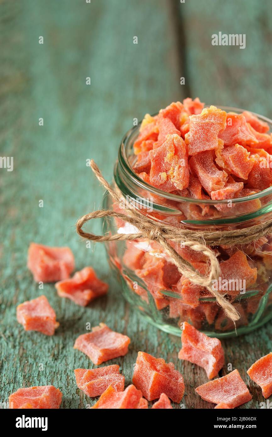 Homemade candied butternut squash pieces in glass jar and scattered on ...