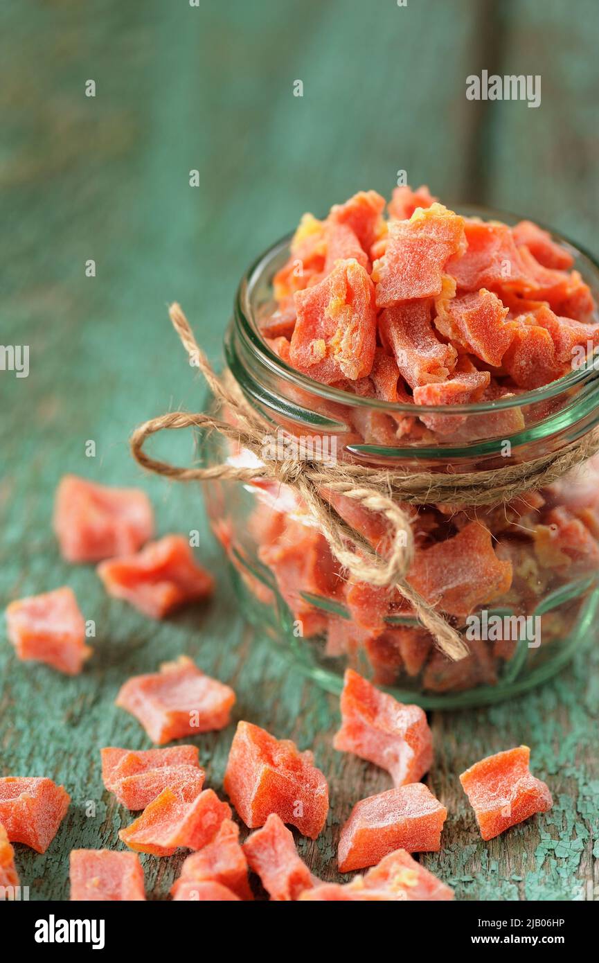 Homemade candied butternut squash pieces in glass jar and scattered on ...
