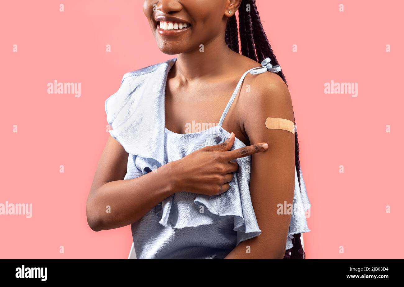 Cropped view of young black lady pointing at adhesive plaster om her ...