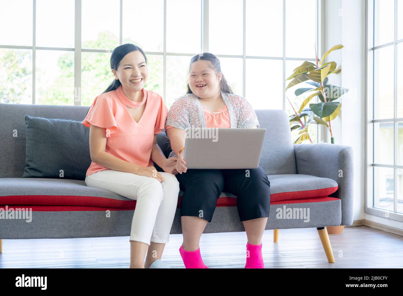 Asian person with Down syndrome using computer with her mom and having ...